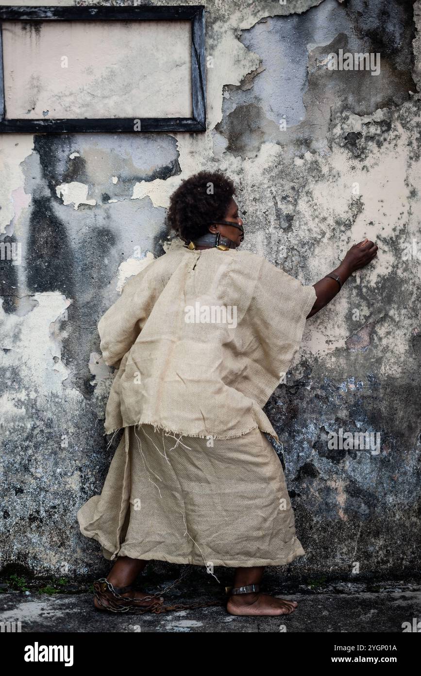 Portrait of a black woman in chains and with an iron mask on her head ...