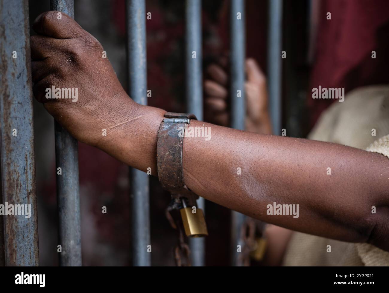 Detail of a chained arm holding an iron fence. Slavery in Brazil ...