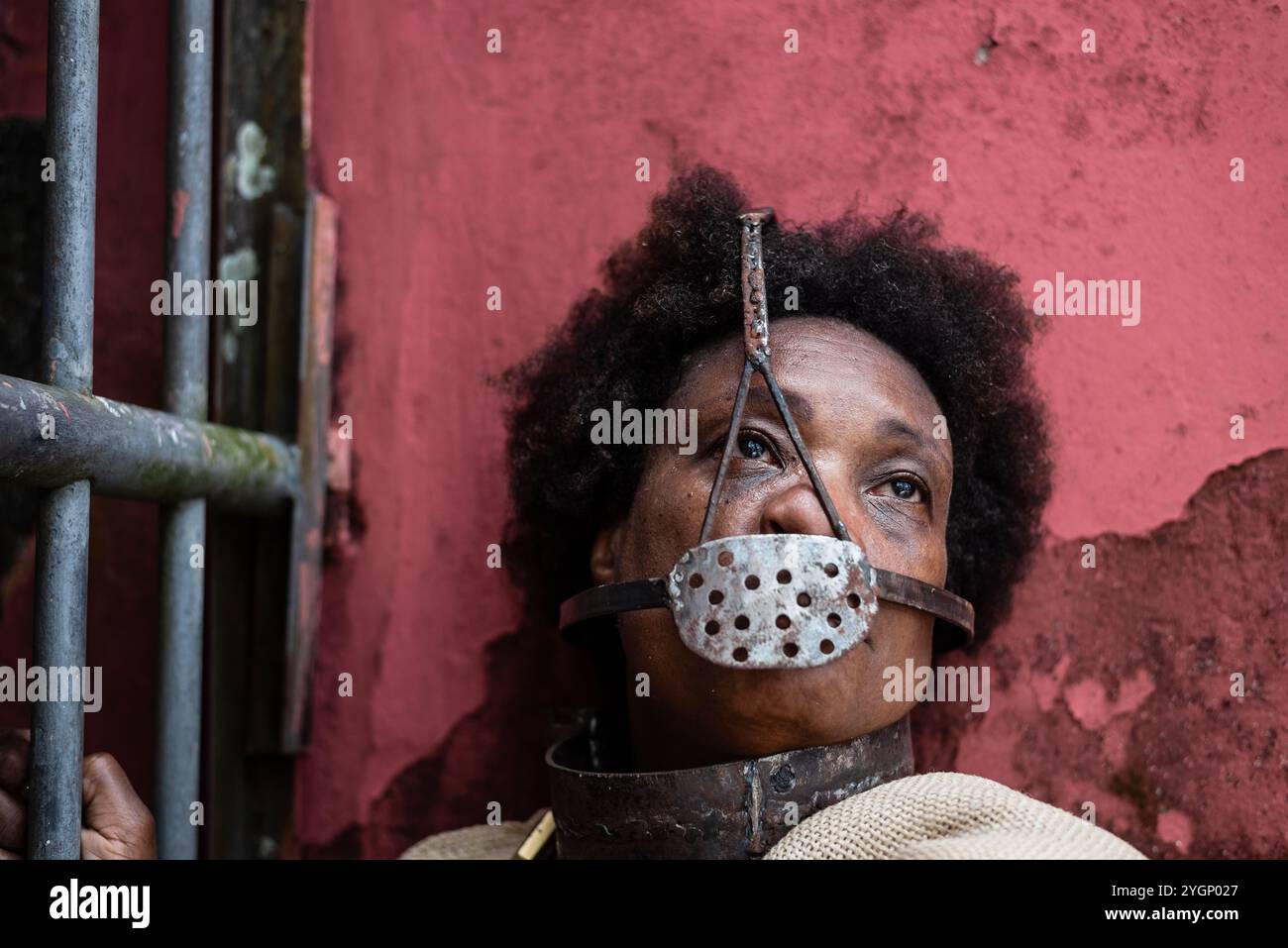 Close-up portrait of a black woman dressed as a slave, chained with an ...