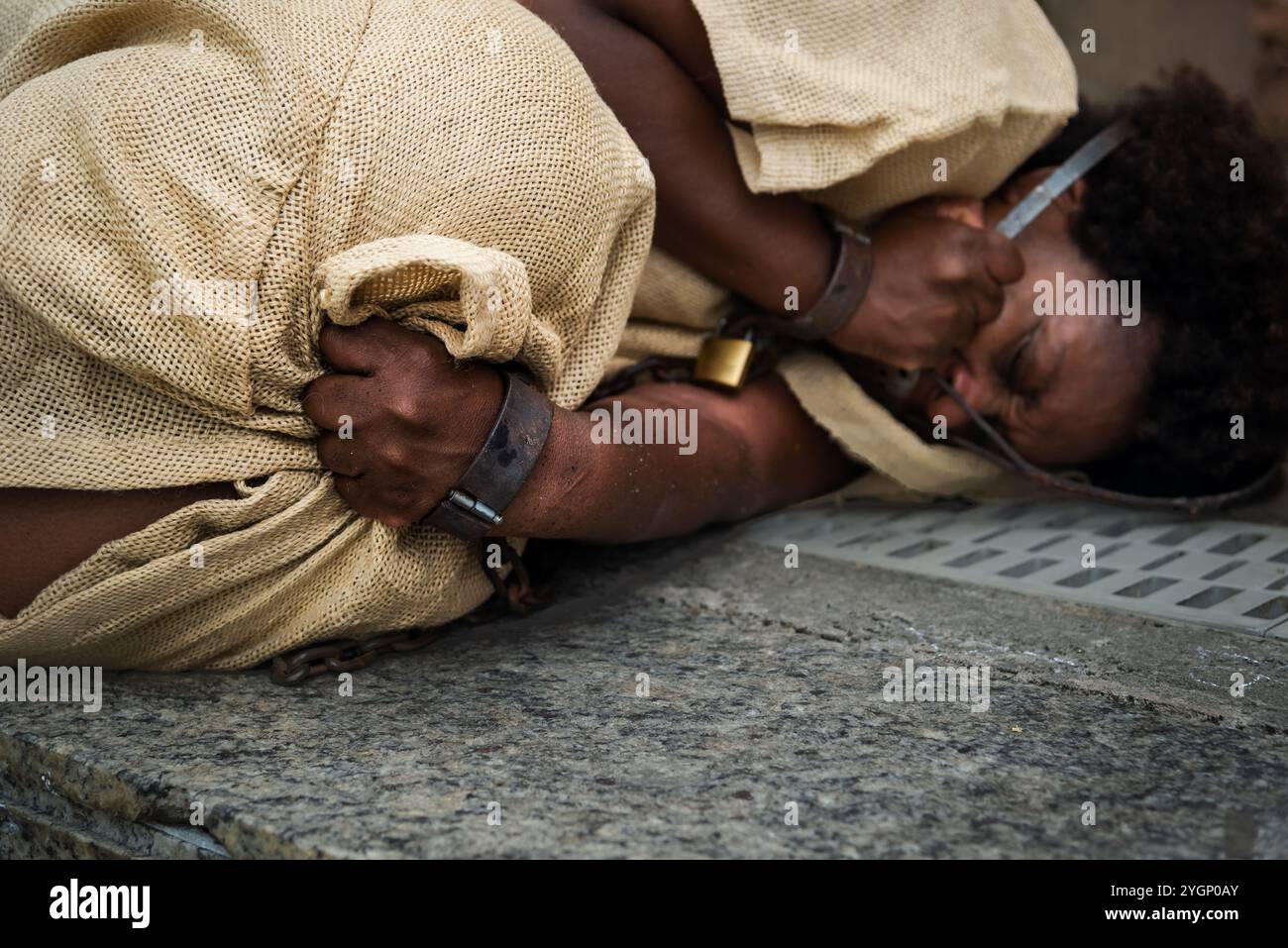 Close-up portrait of the face of a black woman with an iron mask over ...