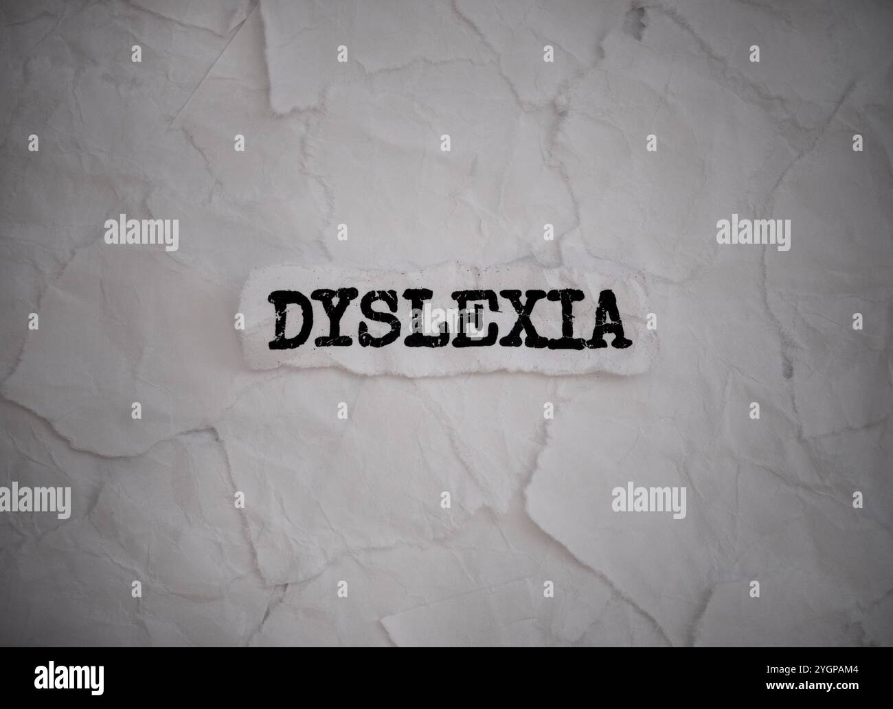 Crumpled piece of paper with word Dyslexia on torn white paper pieces ...
