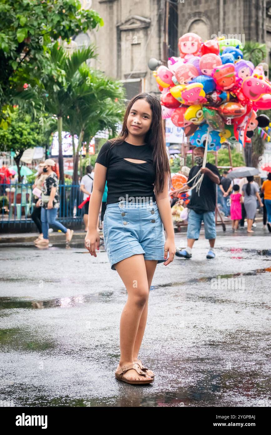 A young Filipino girl poses outside the Santo Nino de Tondo Church in the Binondo district of ...