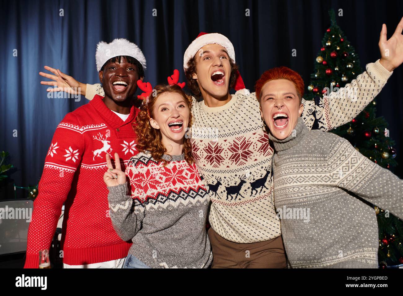 A cheerful group of young coworkers embraces the holiday spirit with ...