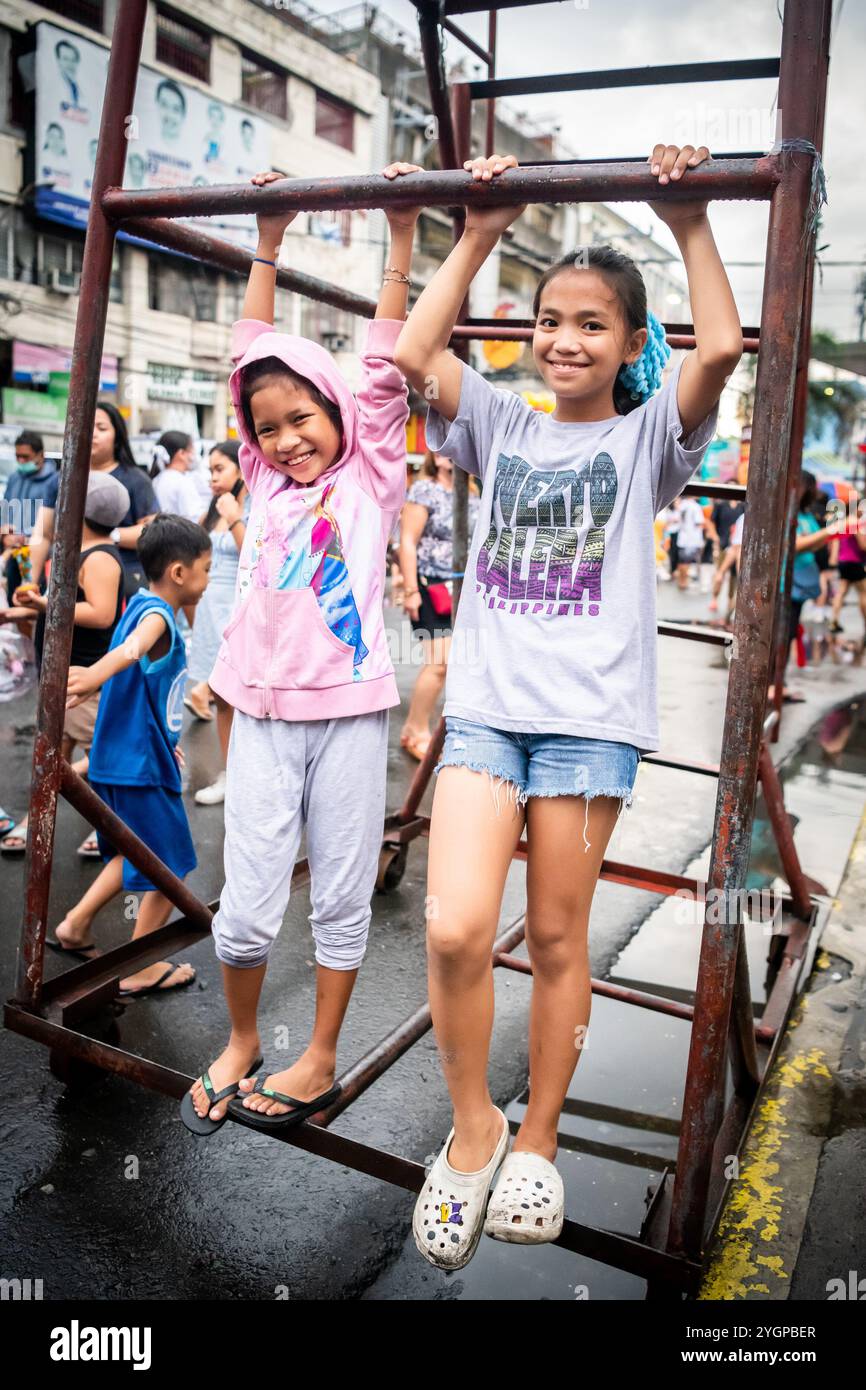 Two young Filipino girls play on a metal frame by the Santo Nino de Tondo Church in the Binondo ...