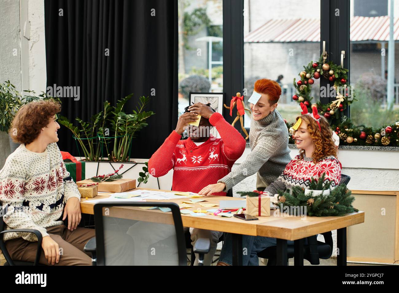 Colleagues in cozy sweaters enjoy laughter and holiday cheer at their ...