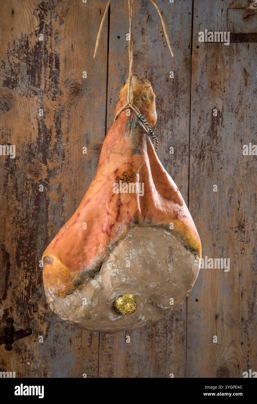 raw ham hanging on a rope with white background Stock Photo - Alamy