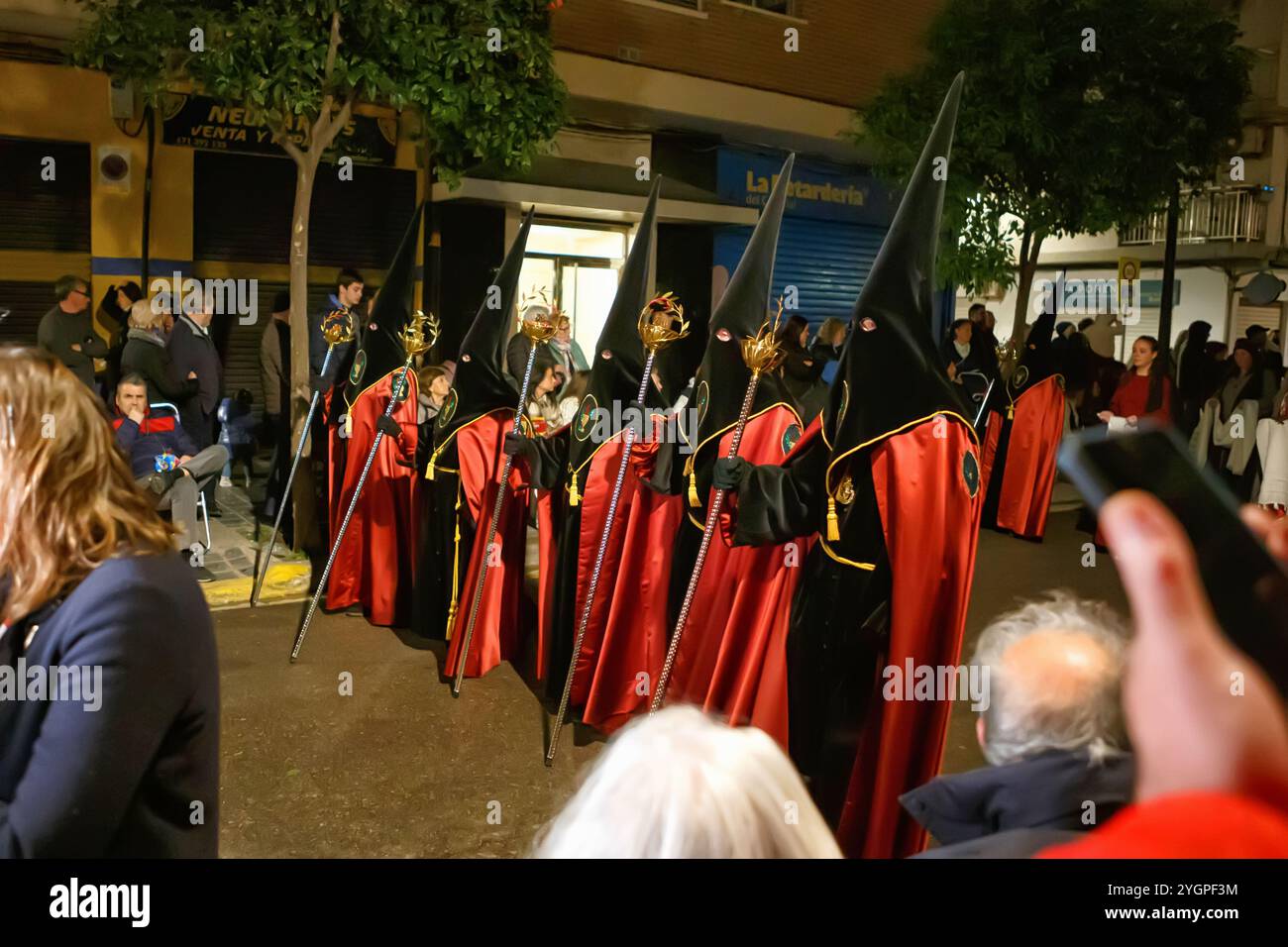 In the evening, participants in traditional attire parade down a busy ...