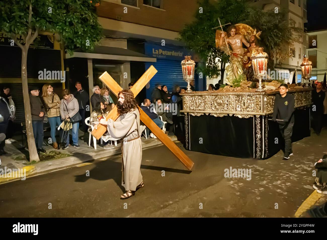 In the evening, participants in traditional attire parade down a busy ...