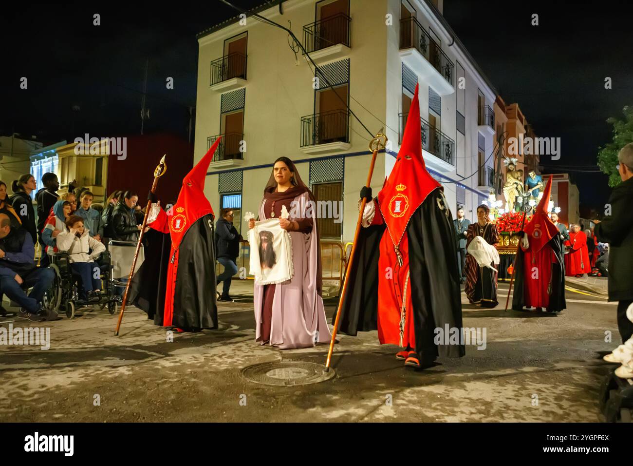 In the evening, participants in traditional attire parade down a busy ...