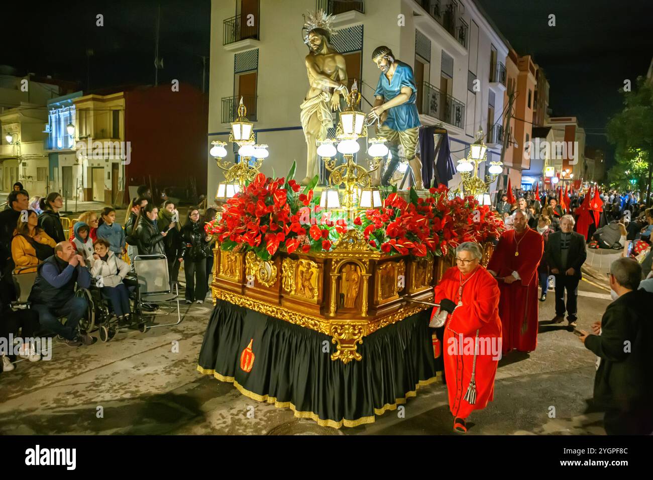 In the evening, participants in traditional attire parade down a busy ...