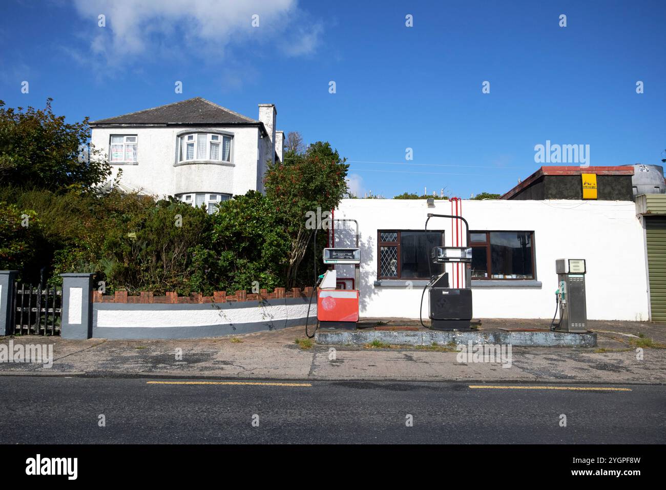 house with small attached garage with rural petrol fuel pumps outside ...