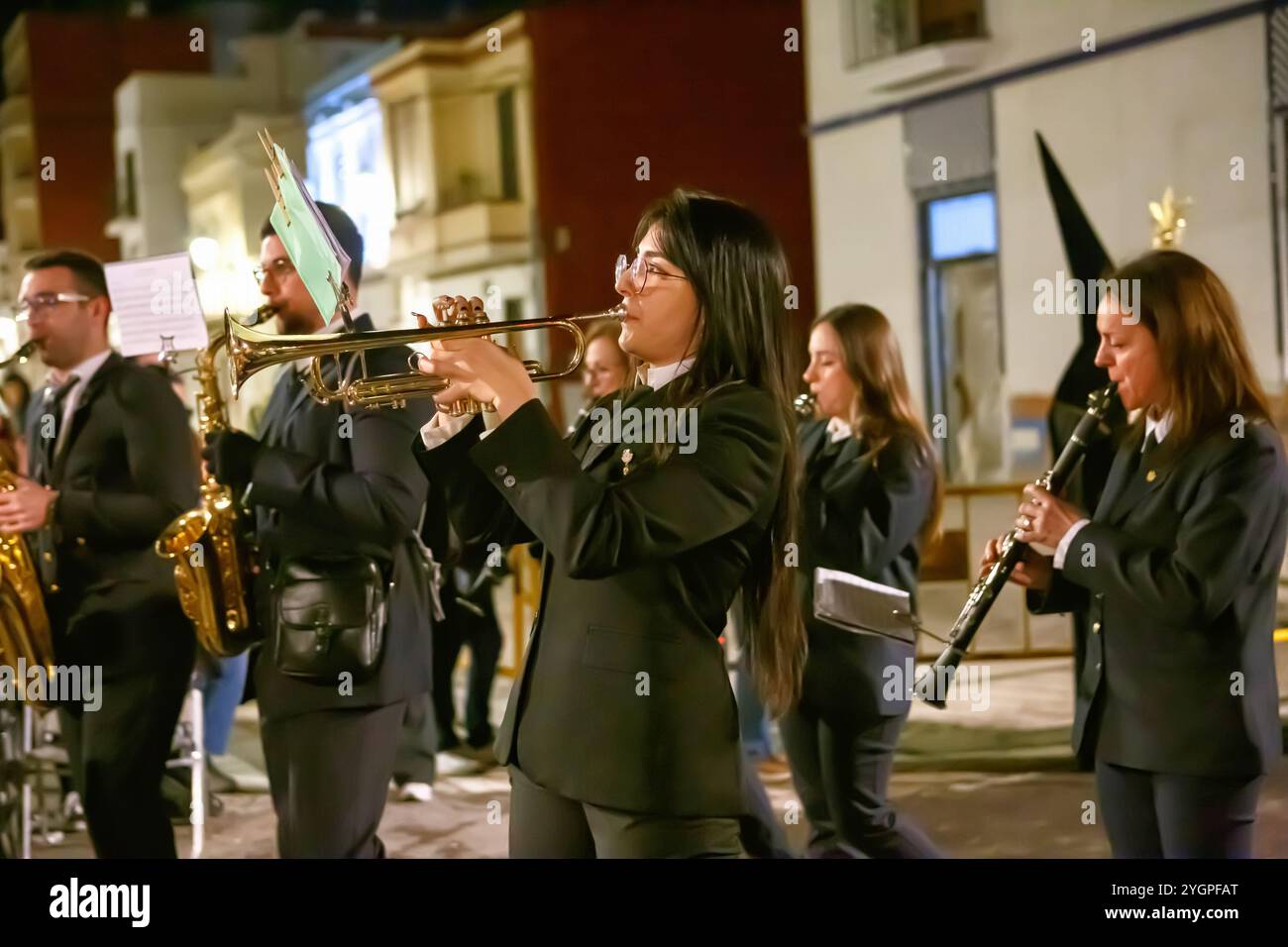 In the evening, participants in traditional attire parade down a busy ...