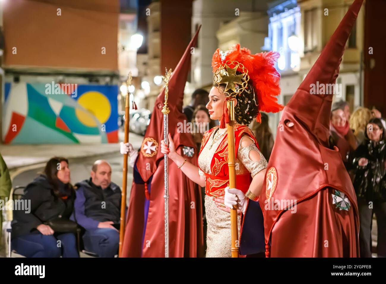 In the evening, participants in traditional attire parade down a busy ...