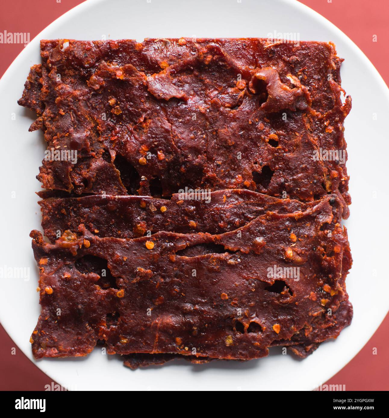 Overhead view of Nigerian kilishi on a white plate, top view of ...