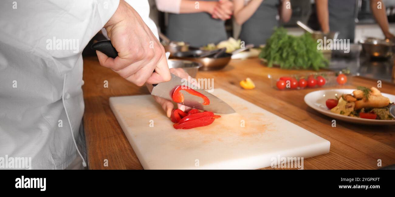Male chef cutting vegetables during cooking classes Stock Photo - Alamy