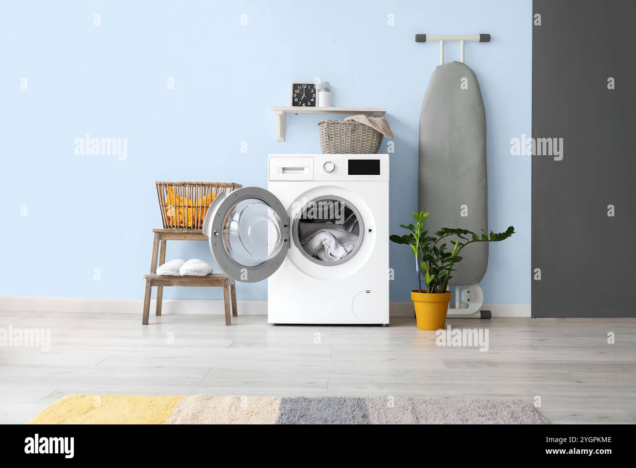 Interior of laundry room with modern washing machine and ironing board ...