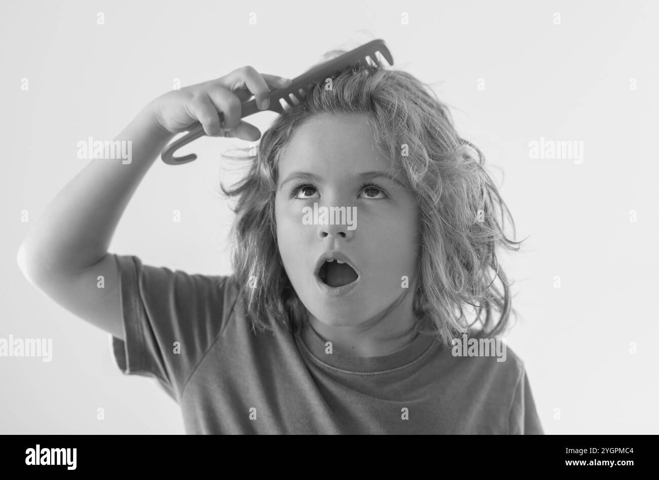 Funny hairstyle. Kid boy makes face expressions, combing hair. Cute ...