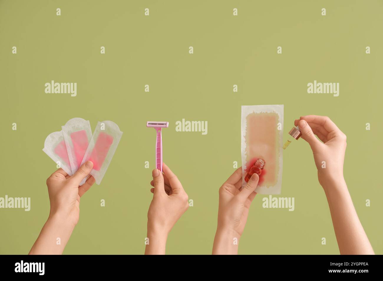 Female hands holding razor, wax strips and pipette with cosmetic oil on ...