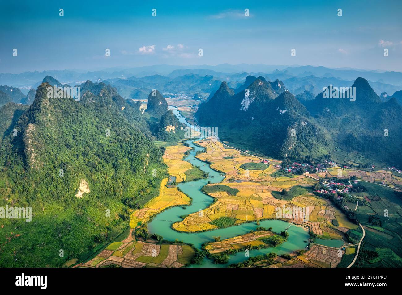 Aerial view of Phong Nam Valley with rice field and river flows through traditional village in ...
