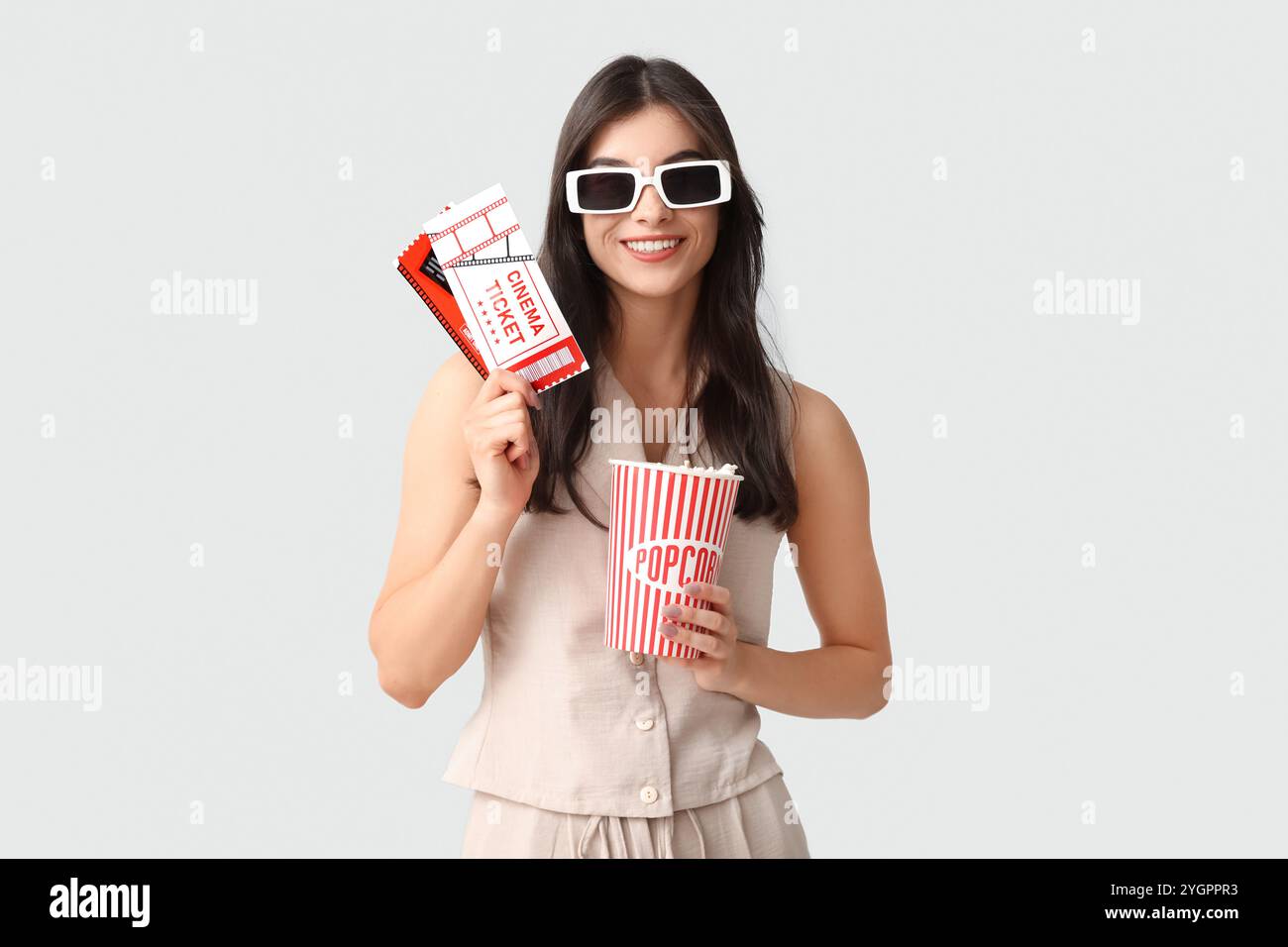 Young pretty woman in 3D cinema eyeglasses with popcorn bucket and ...