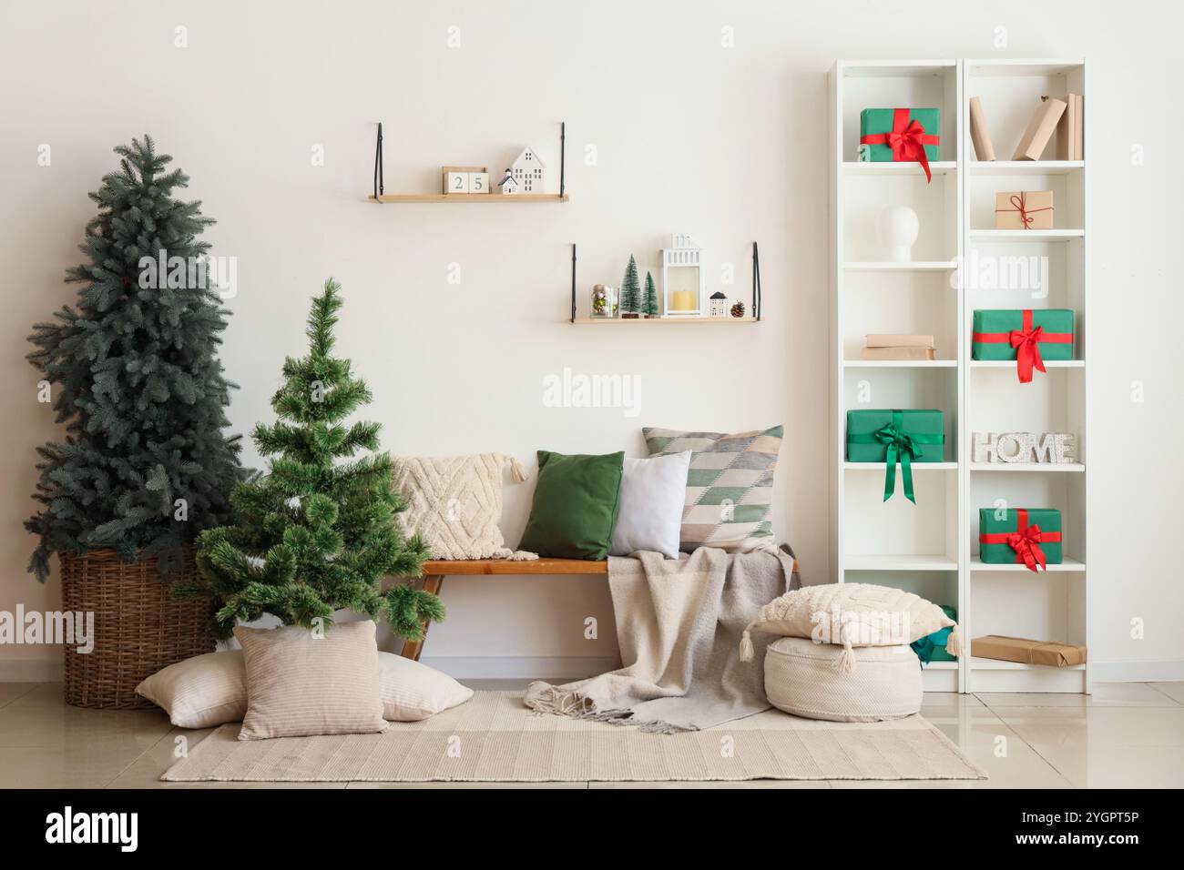Christmas trees, bench and shelving unit in interior of living room ...