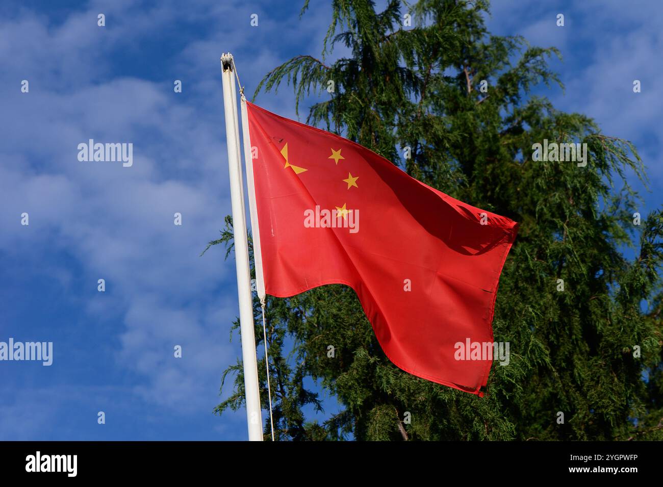 The bright red flag of China flutters gently, showcasing its iconic ...