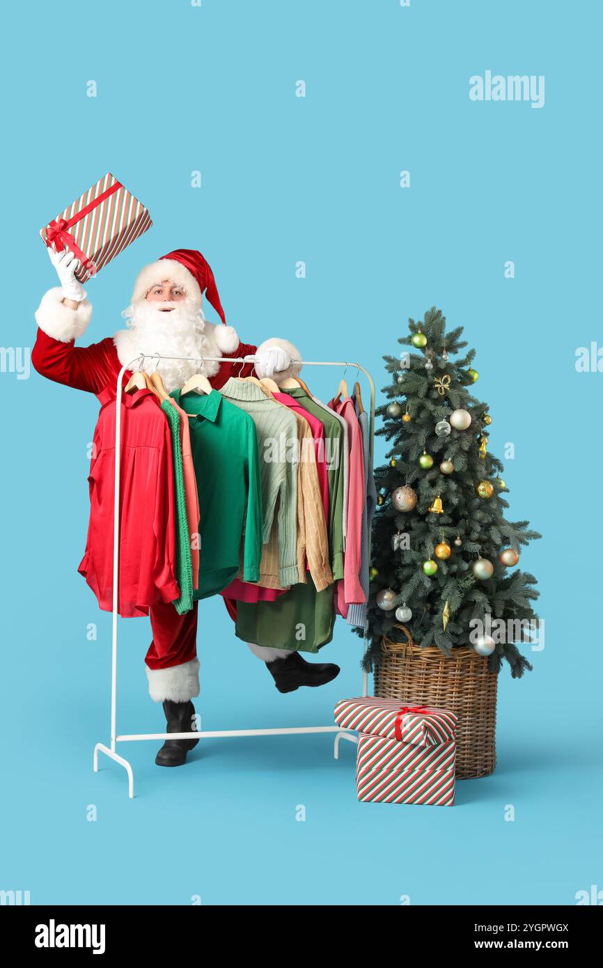 Santa Claus near rack with different clothes, gift boxes and Christmas ...