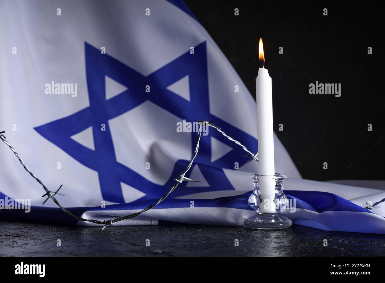 Flag of Israel with burning candle and barbed wire on black background ...