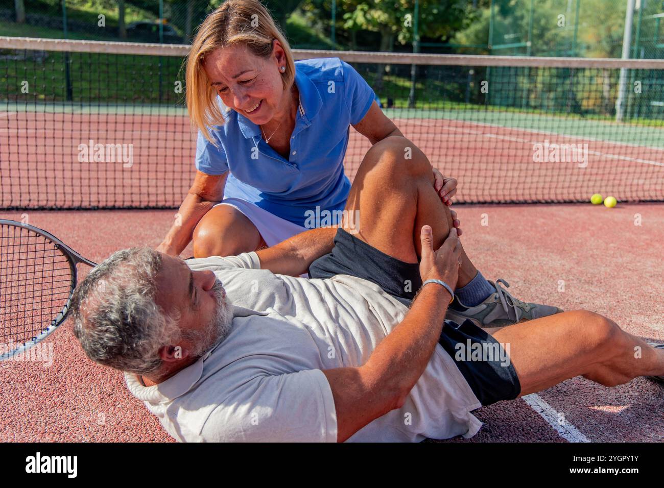 closeup senior female tennis player provides care to her partner, who ...