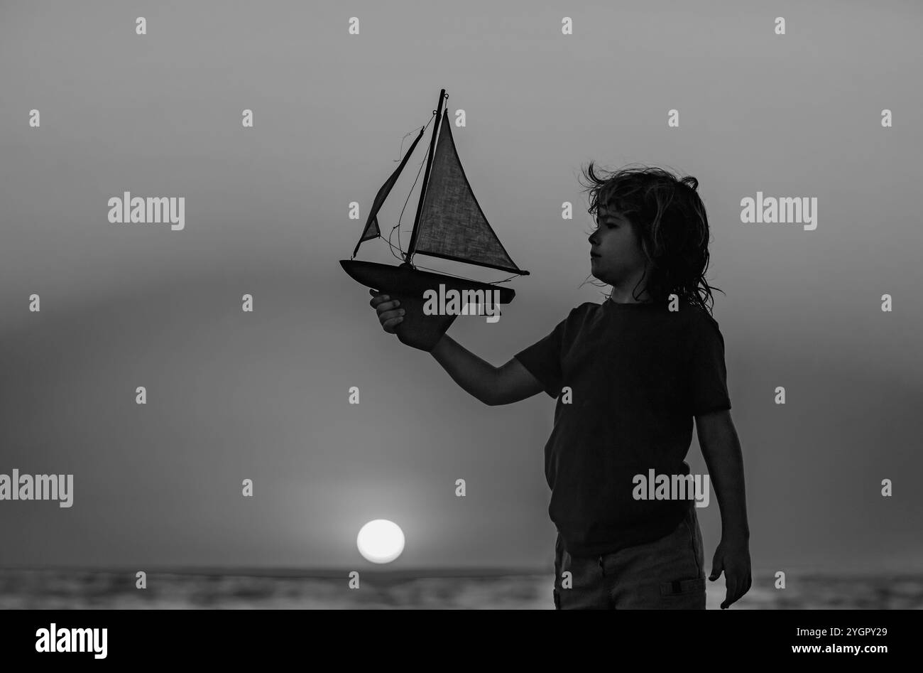 Child with toy boat in sea water on summer vacation. Little child ...