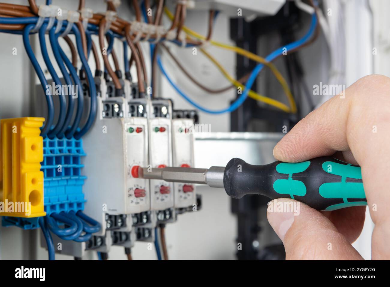 Hand Using Screwdriver on Electrical Terminal Block Stock Photo - Alamy