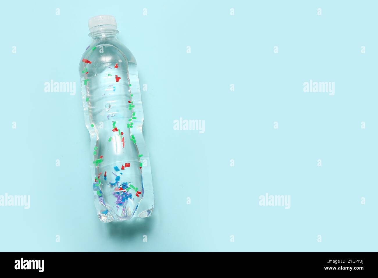 Bottle of water with plastic on blue background. Microplastic Awareness ...