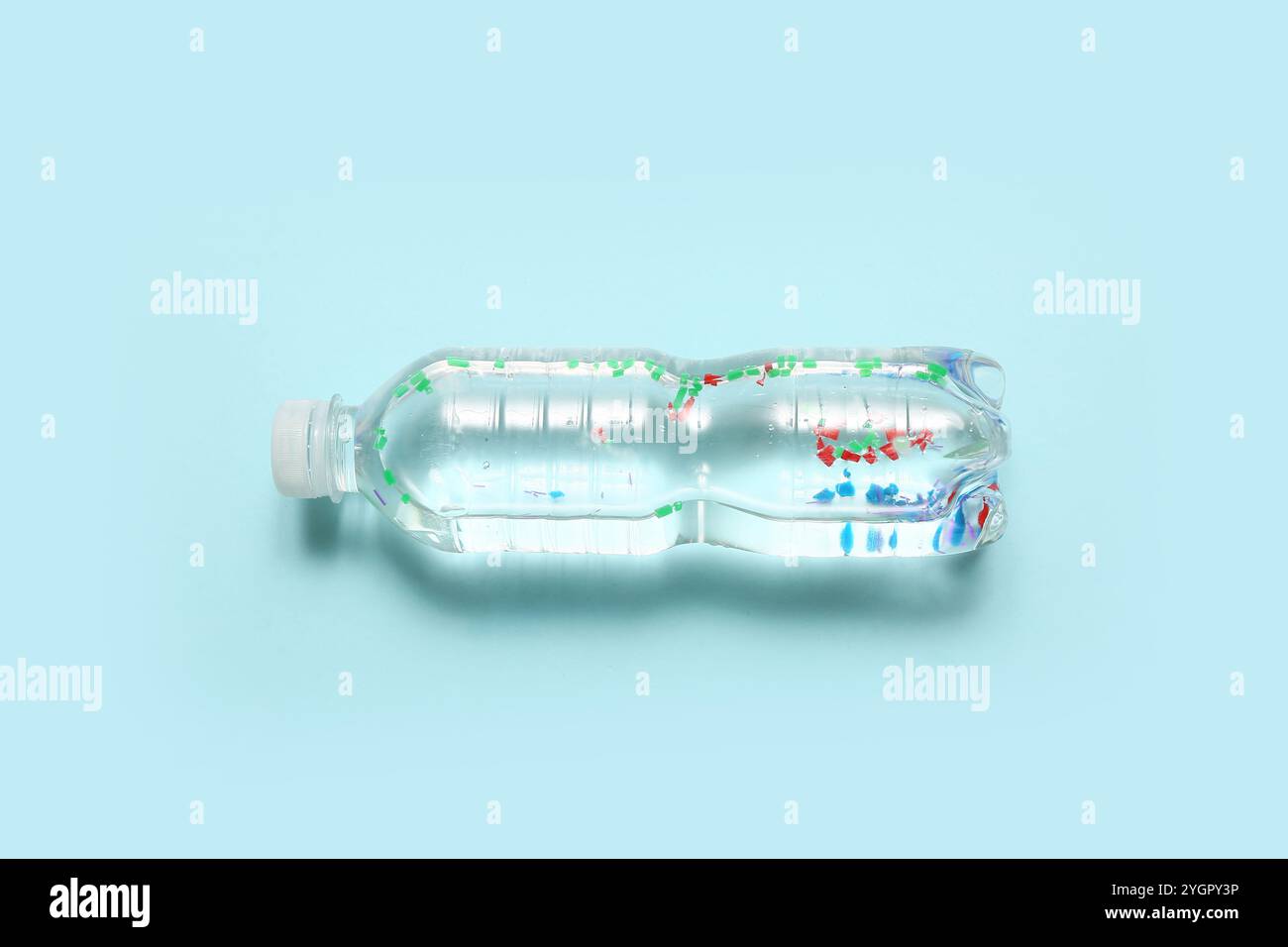 Bottle of water with plastic on blue background. Microplastic Awareness ...