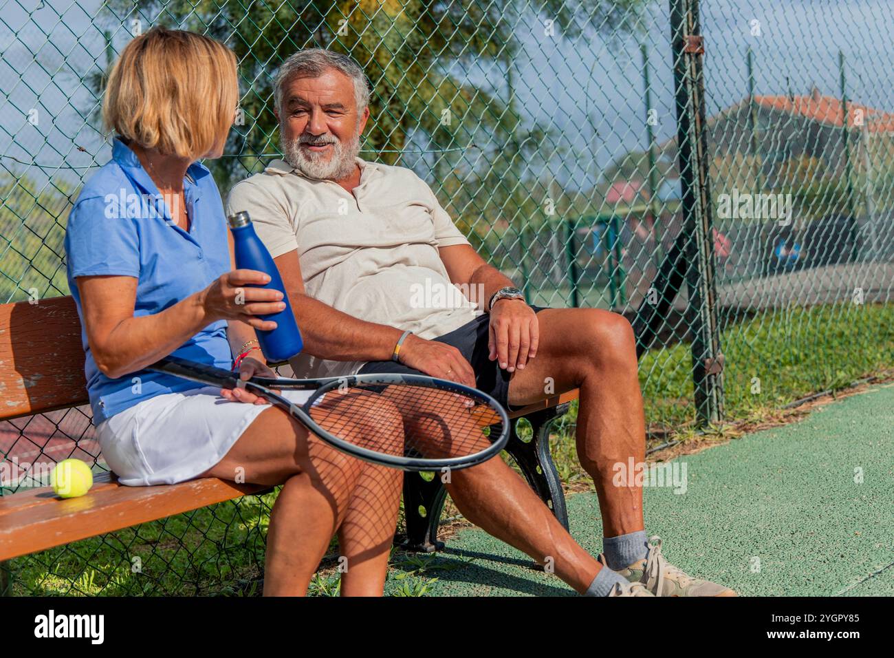 closeup smiling senior tennis player engages in a friendly conversation ...