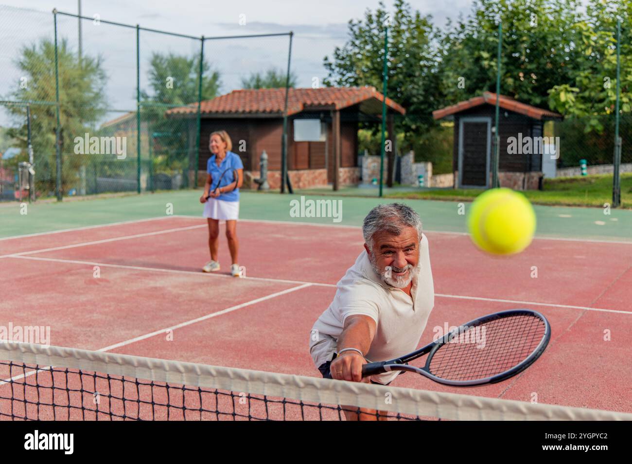 close-up shot of a senior tennis player executing a backhand shot ...