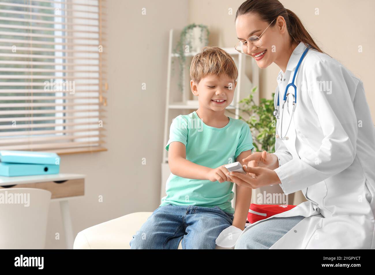 Little diabetic boy with doctor using glucometer in clinic Stock Photo ...
