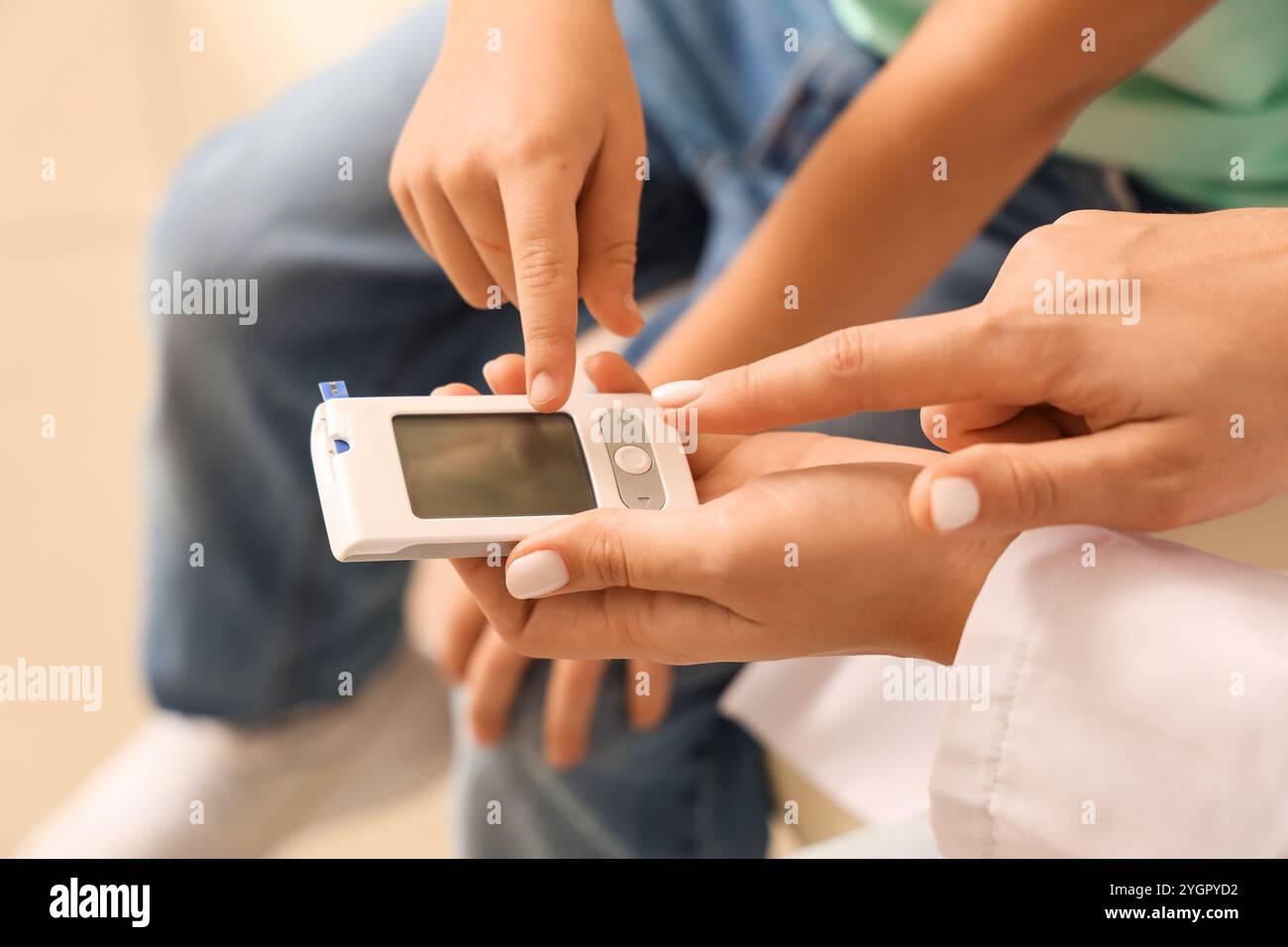 Little diabetic boy with doctor using glucometer in clinic, closeup ...