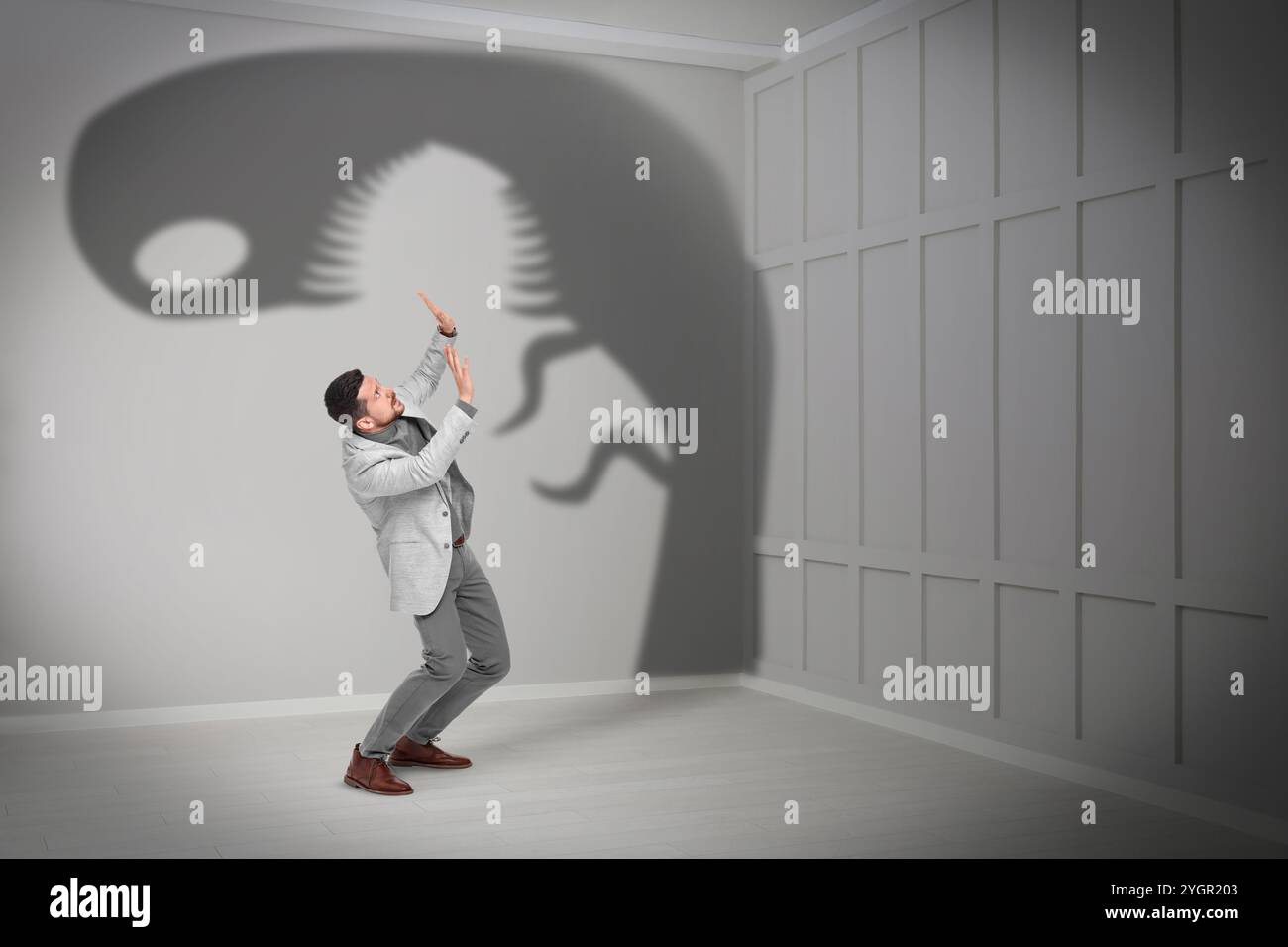 Businessman scared by monster. Scary shadow in room Stock Photo - Alamy