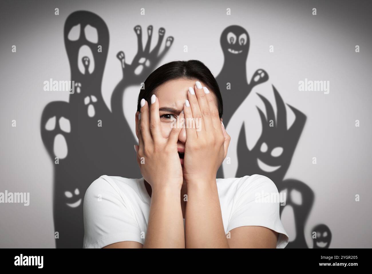 Woman scared by monsters. Scary shadows on white wall Stock Photo - Alamy