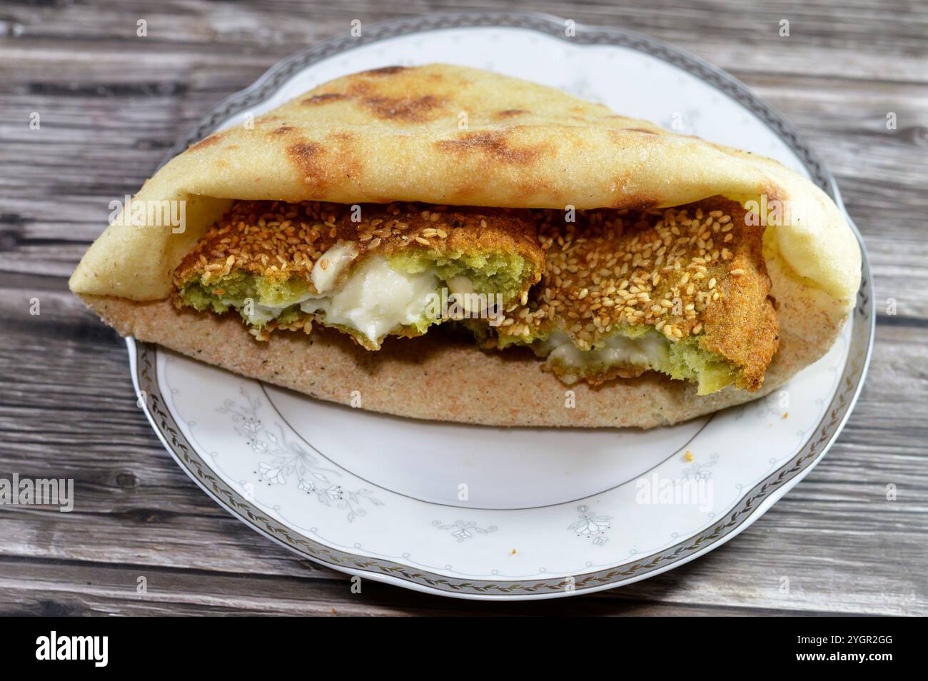 Traditional Egyptian flat bread filled with fried falafel balls, green ...