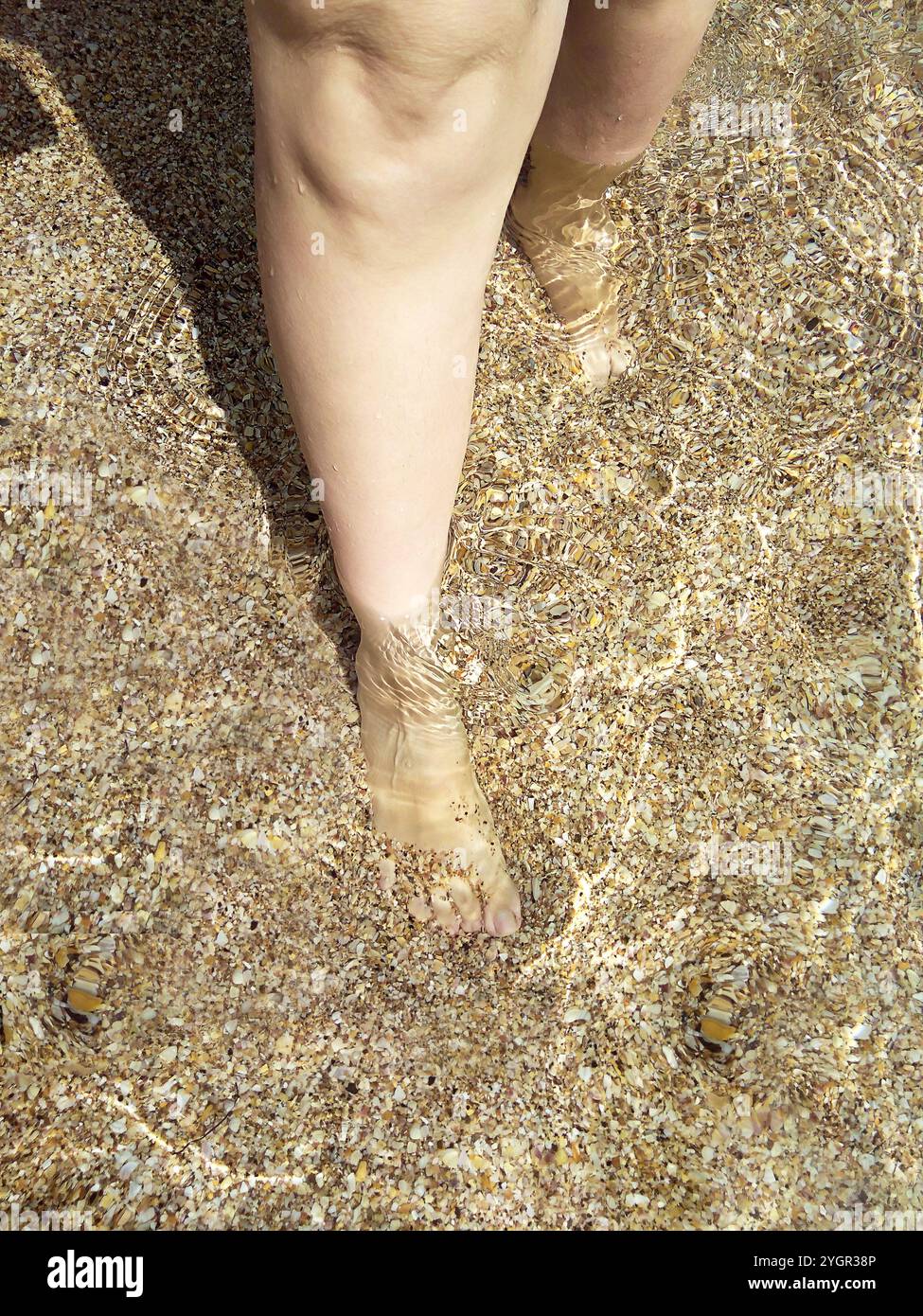 Barefoot Serenity: Feet in Water on a Tranquil Beach Stock Photo - Alamy