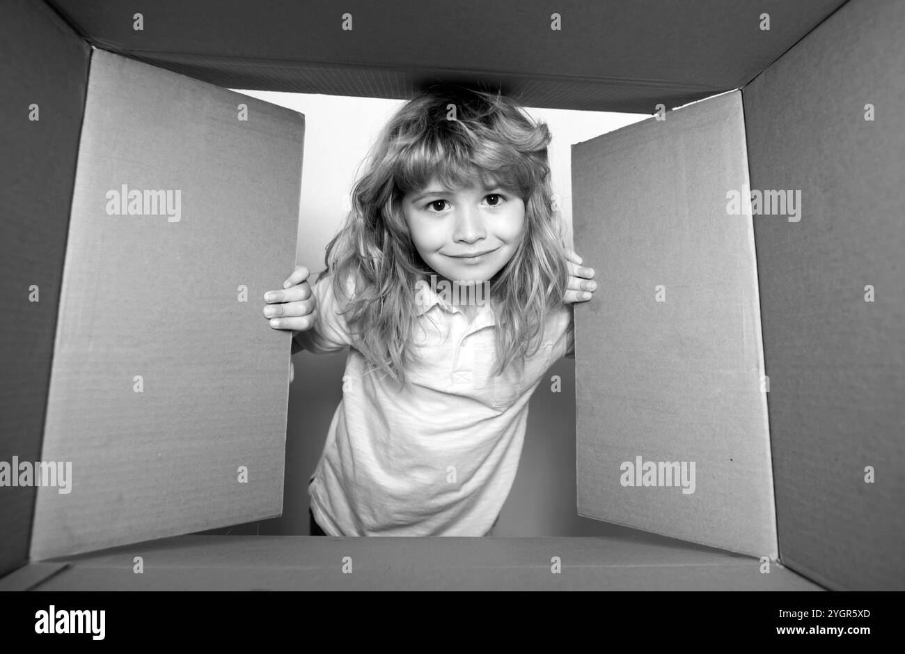 Kid open paper cardboard box. Cheerful cute child opening a present ...