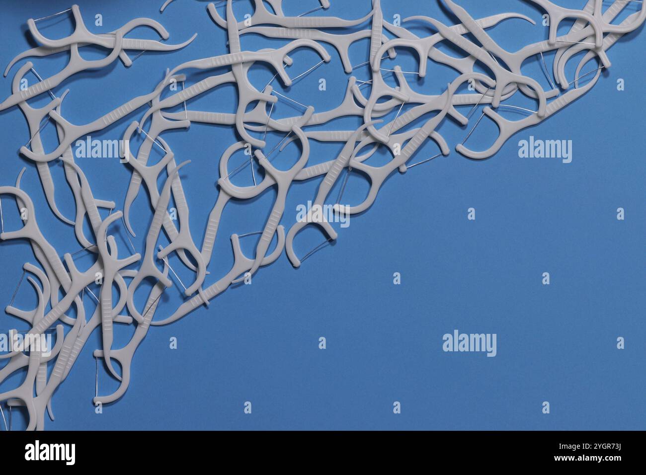 An image of white interdental toothpicks with a thread on a blue ...