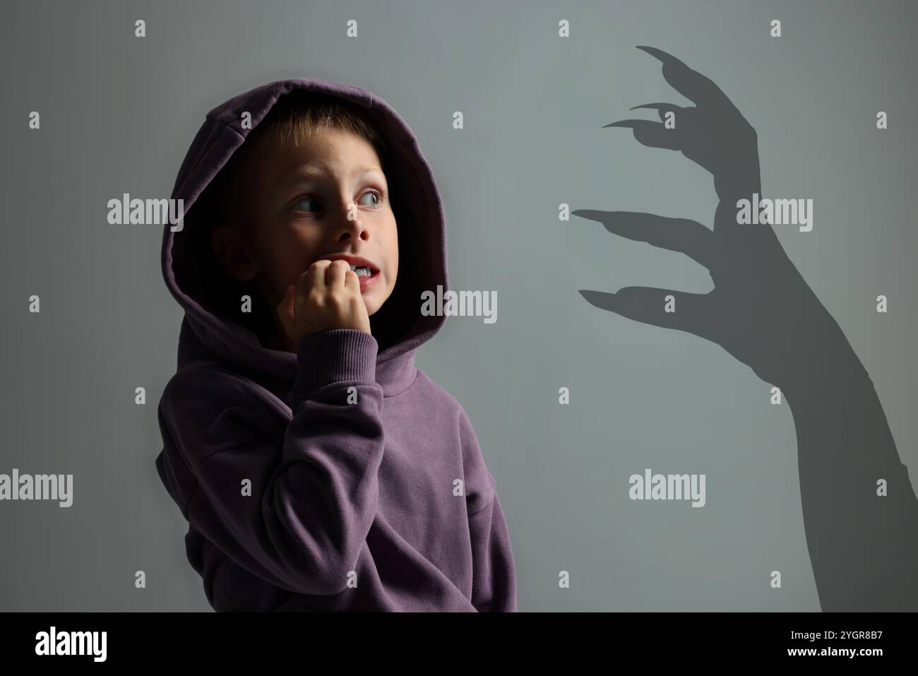 Teraphobia - fear of monsters. Scared boy looking at creepy hand. Grey ...