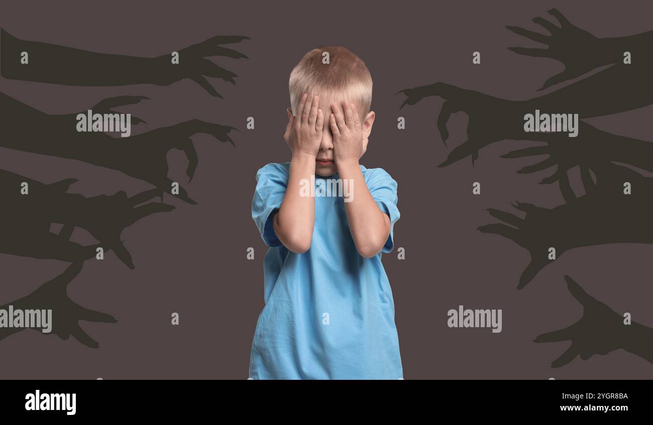 Teraphobia - fear of monsters. Scared boy covering his eyes on dark ...
