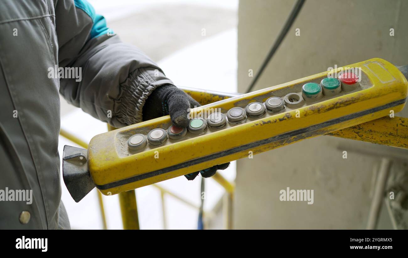 Control panel for cranes in the hands of a worker. Male hand push ...