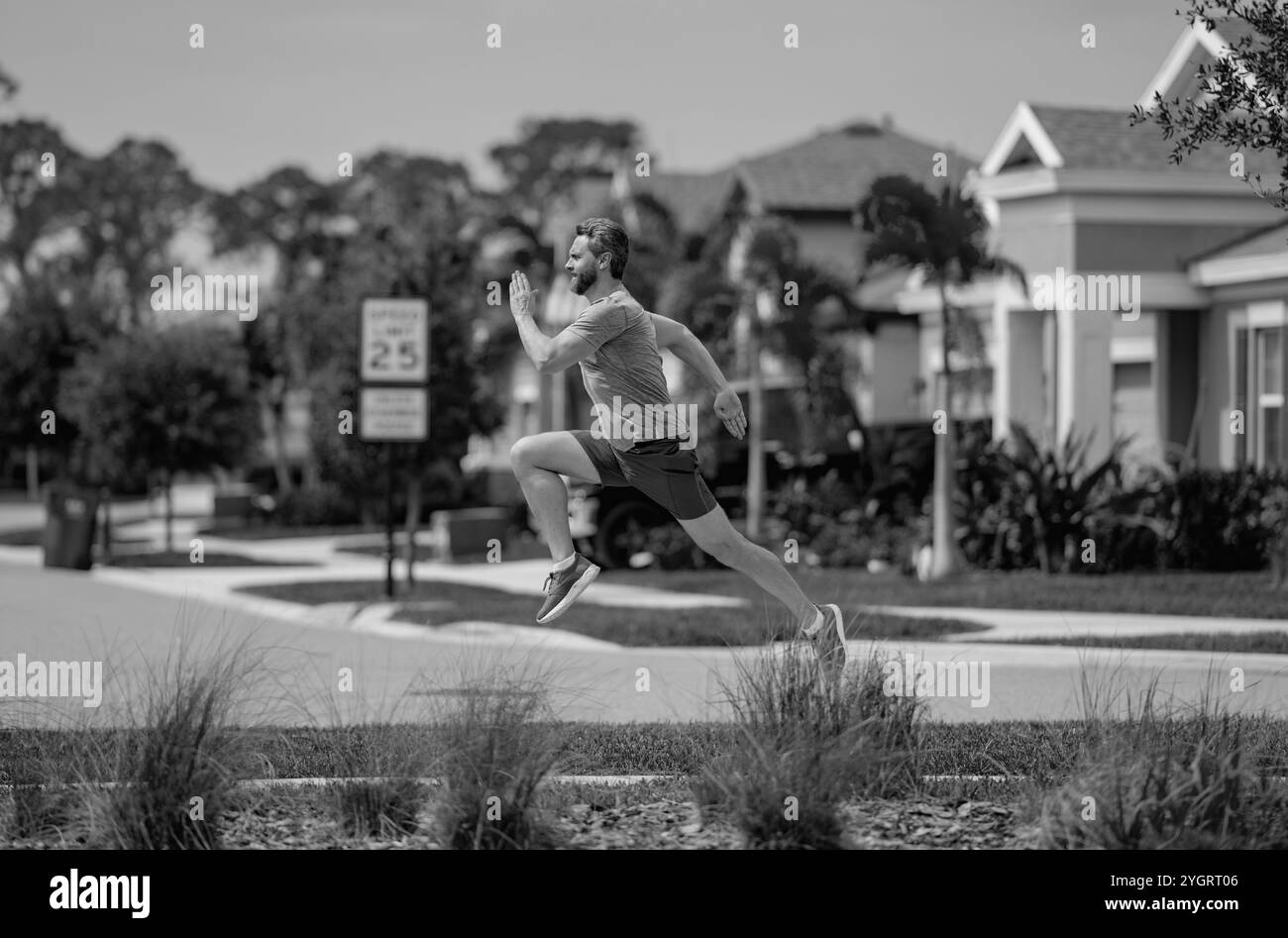 Man running on street in neighborhood. Handsome athlete running in the ...