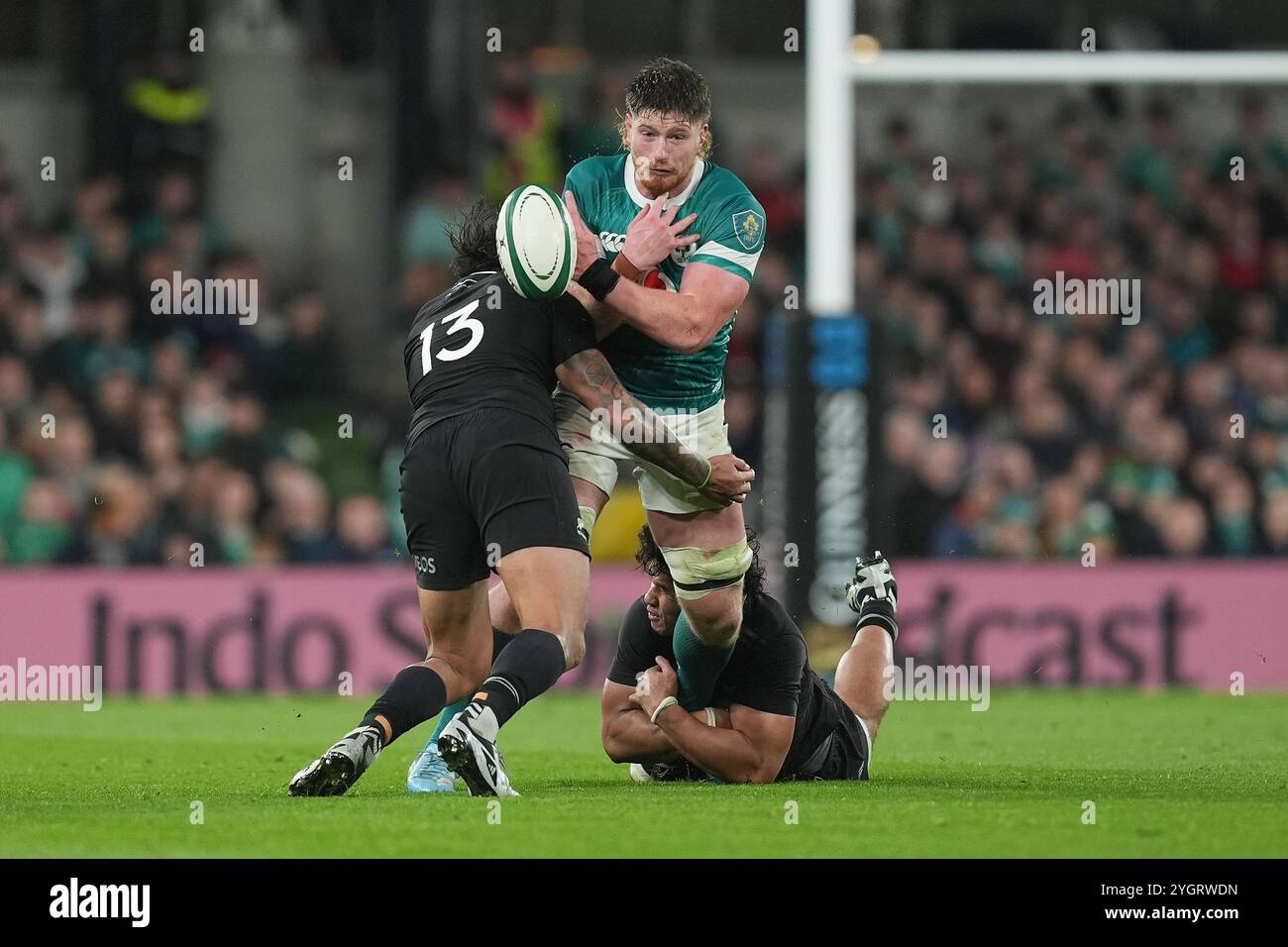 Ireland's Joe McCarthy (centre) is tackled by New Zealand's Wallace ...