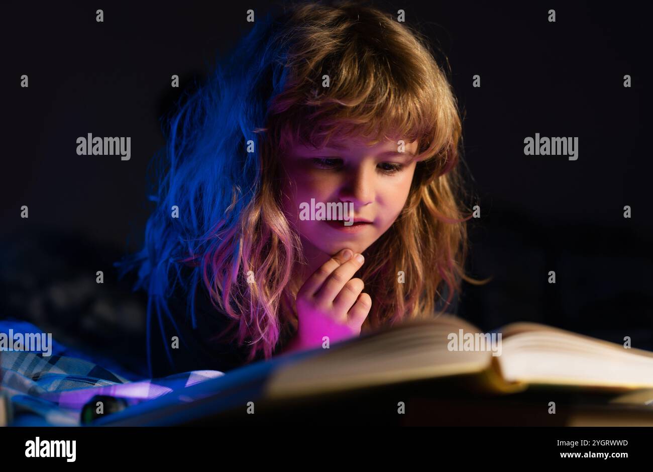 Happy childhood, dreaming child. Child reading a book in bed before ...