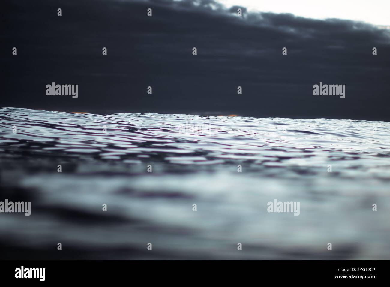 Ripples on the ocean meet the horizon at dusk in Waikiki Stock Photo ...